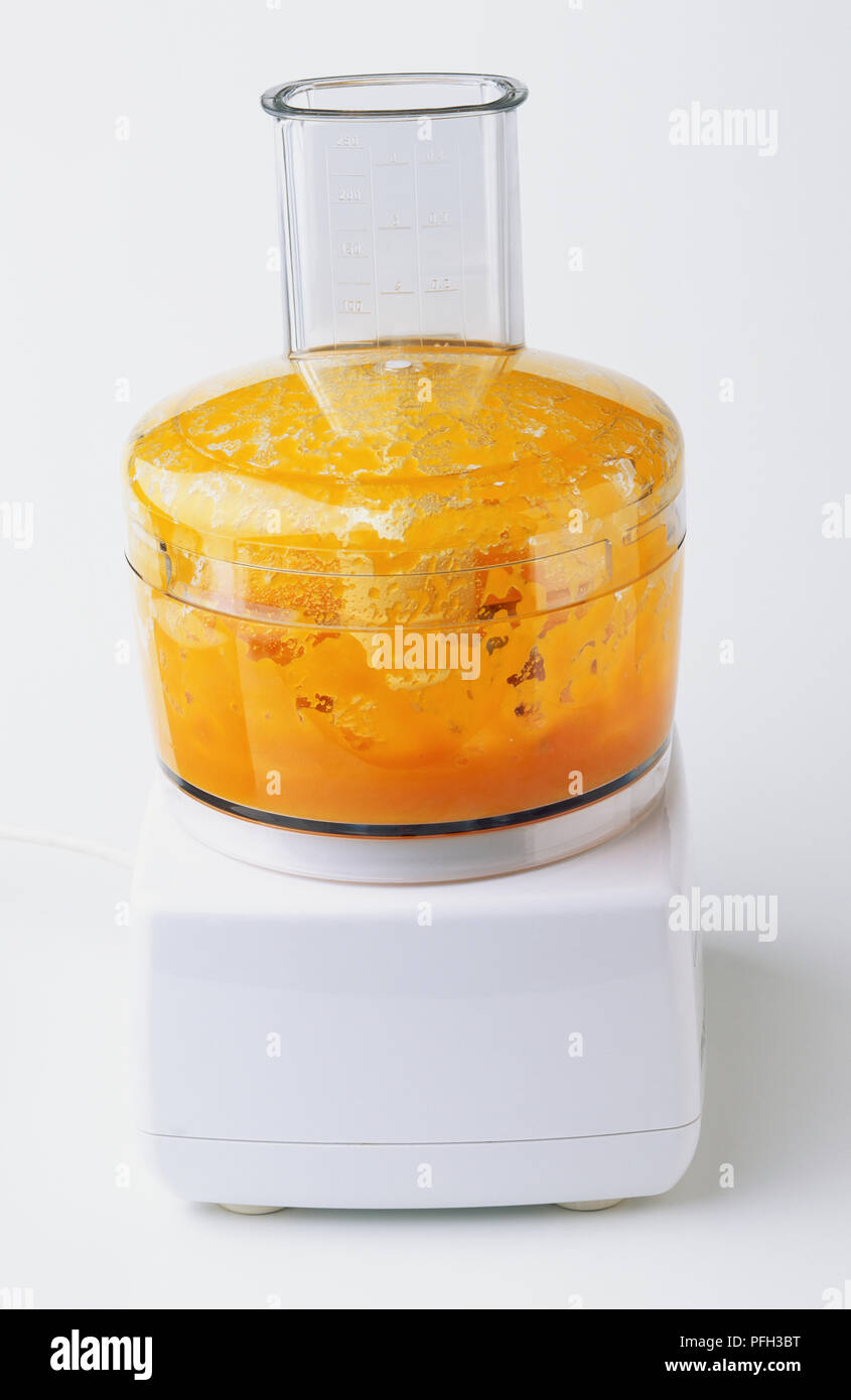 Orange mixture splashed inside food processor container, side view ...