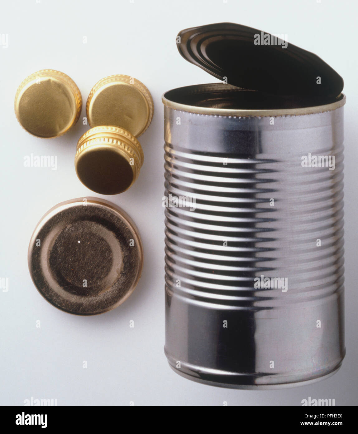 Empty open tin can, three bottle lids and small jar lid, close up Stock ...