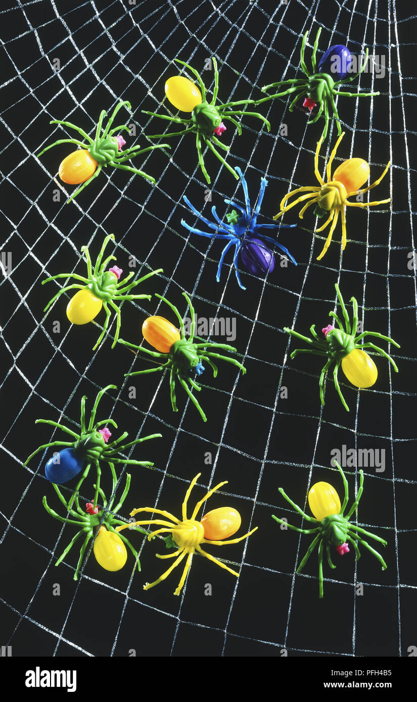 Twelve blue, yellow and green plastic spiders in a web Stock Photo - Alamy