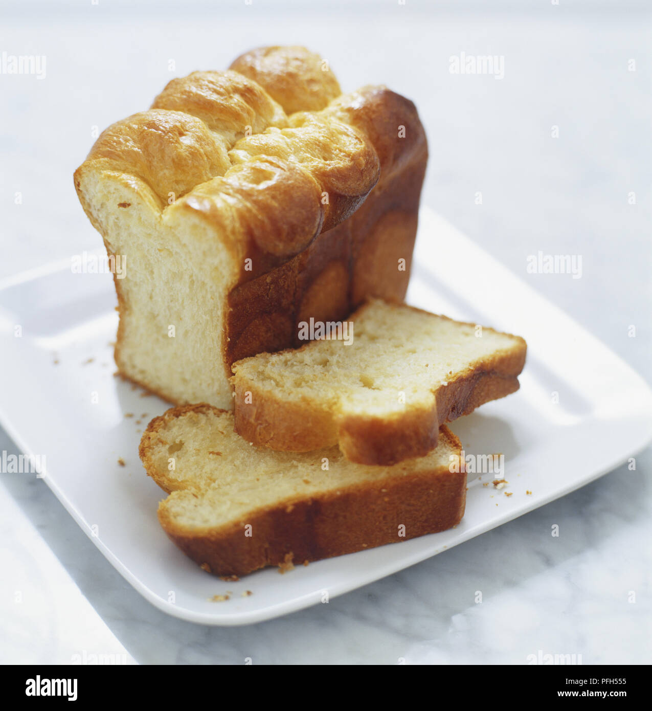 Brioche Nanterre, loaf cake with two slices cut away served on a square ...