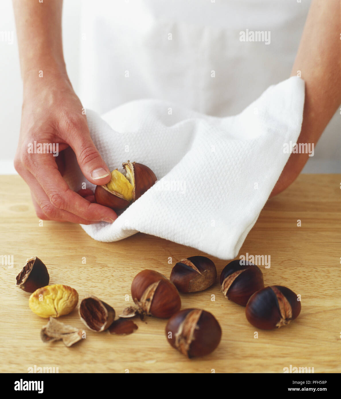 Peeling off skin of split chestnuts Stock Photo - Alamy