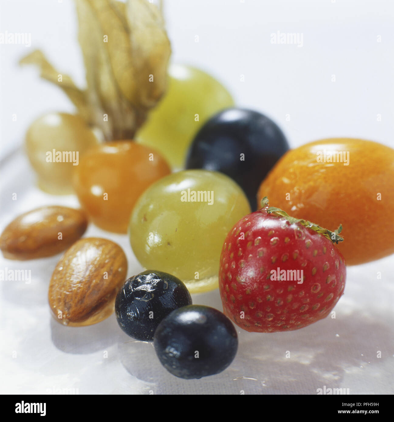 Selection of sugar-dipped fruit and nuts, including grapes, kumquats ...