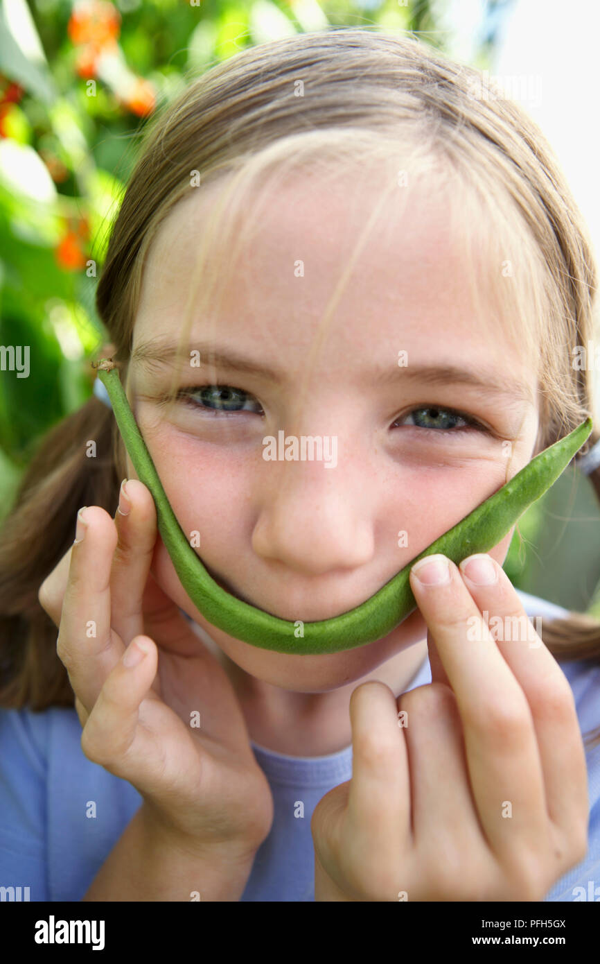 Girl making runner bean smile Stock Photo - Alamy