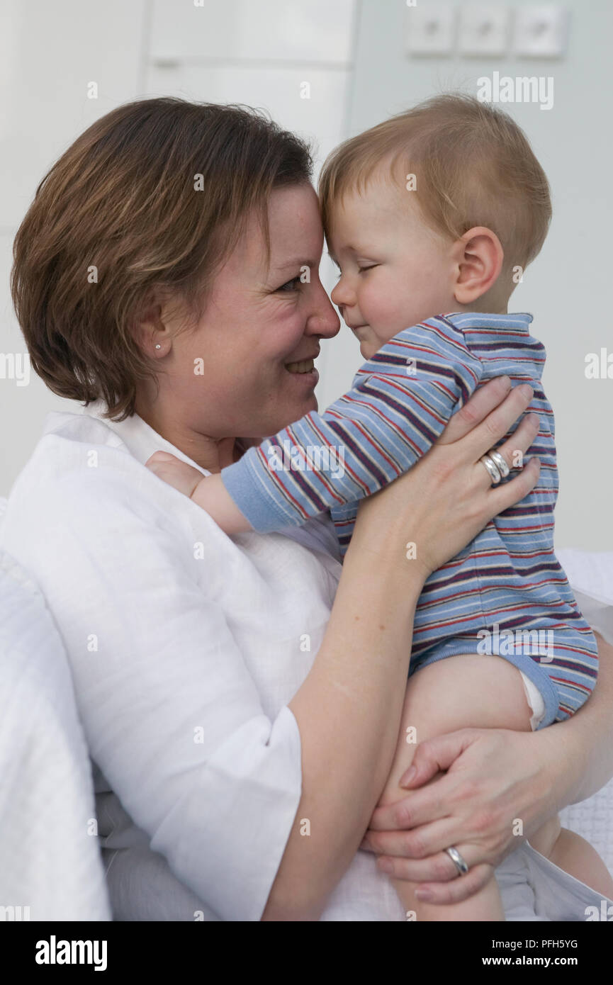 Woman carrying baby boy, smiling Stock Photo - Alamy