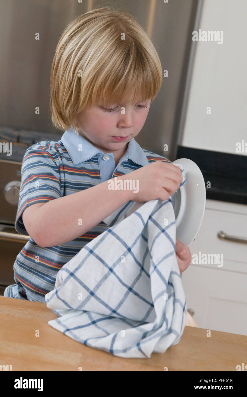 Boy drying plate in kitchen Stock Photo - Alamy