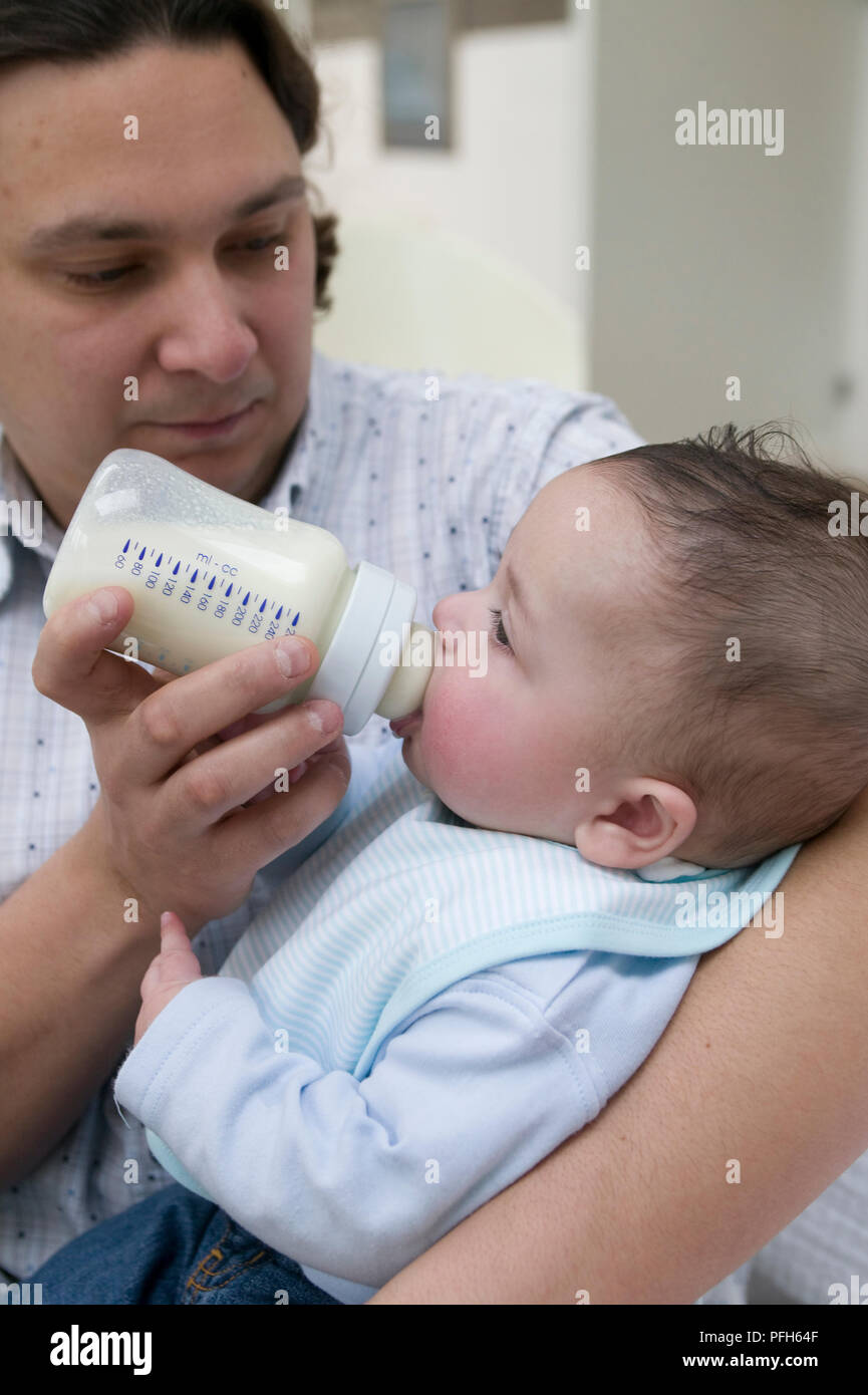 Man feeding baby boy with bottle Stock Photo - Alamy