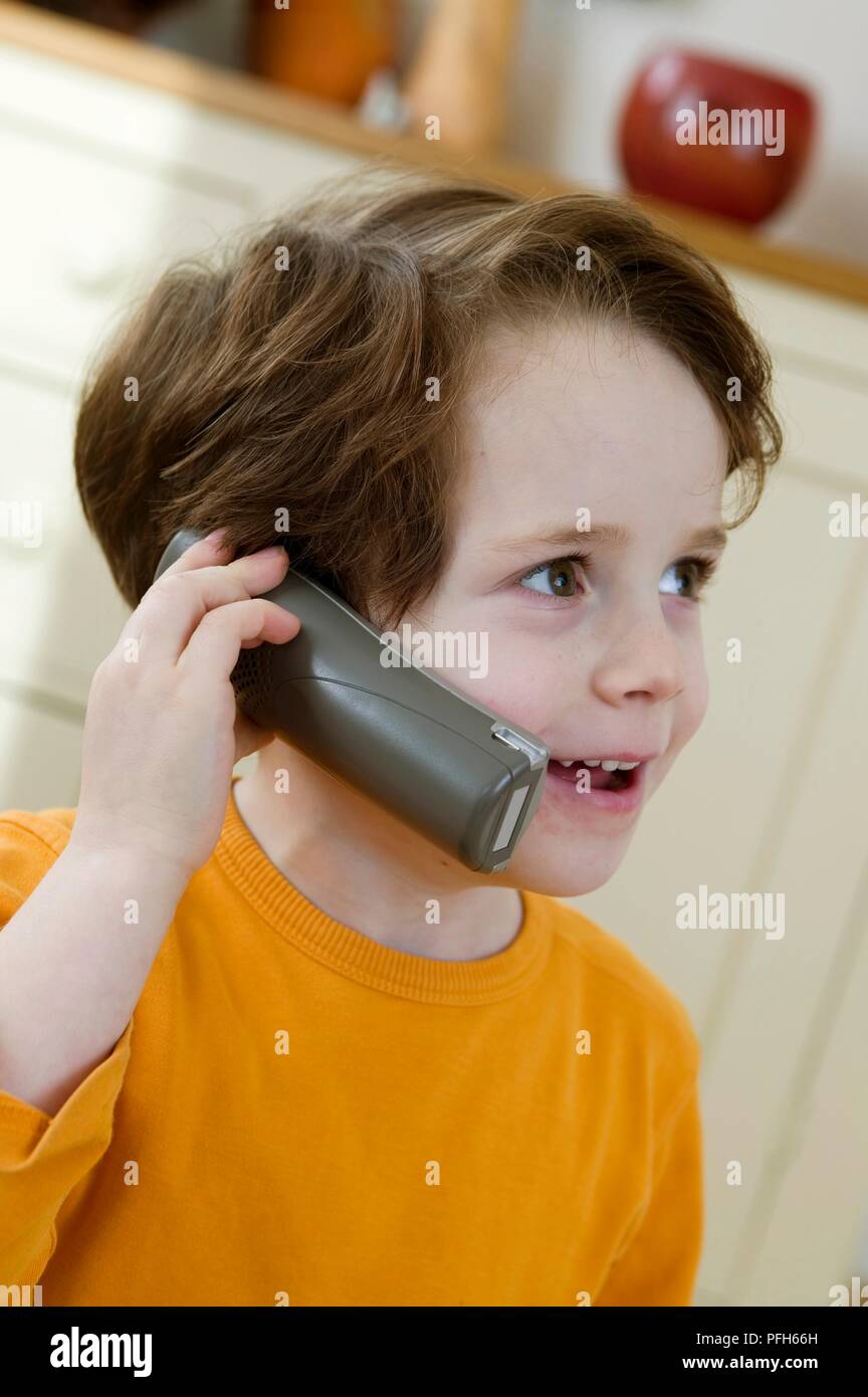 Boy holding mobile phone to ear, smiling Stock Photo - Alamy