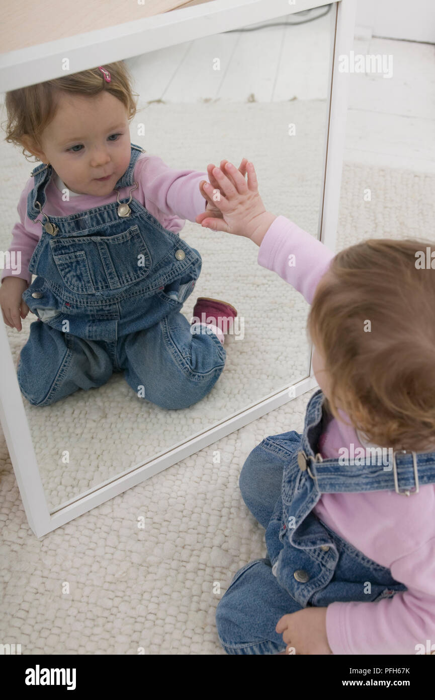Girl touching mirror, high angle view Stock Photo - Alamy