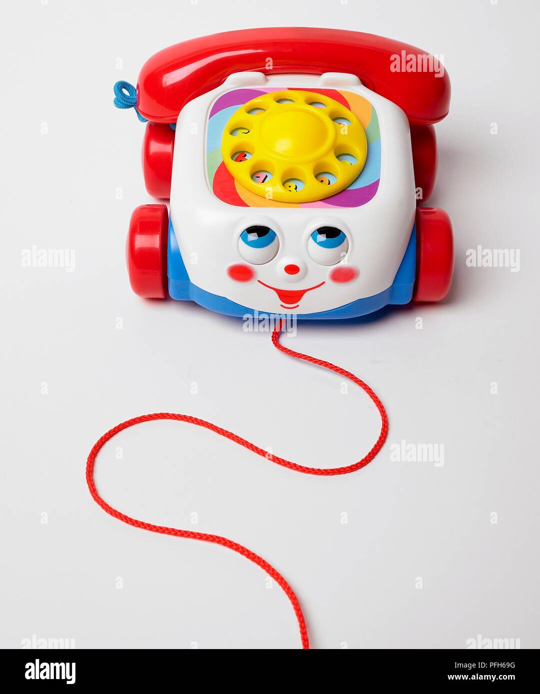 Plastic toy phone with face and wheels Stock Photo - Alamy