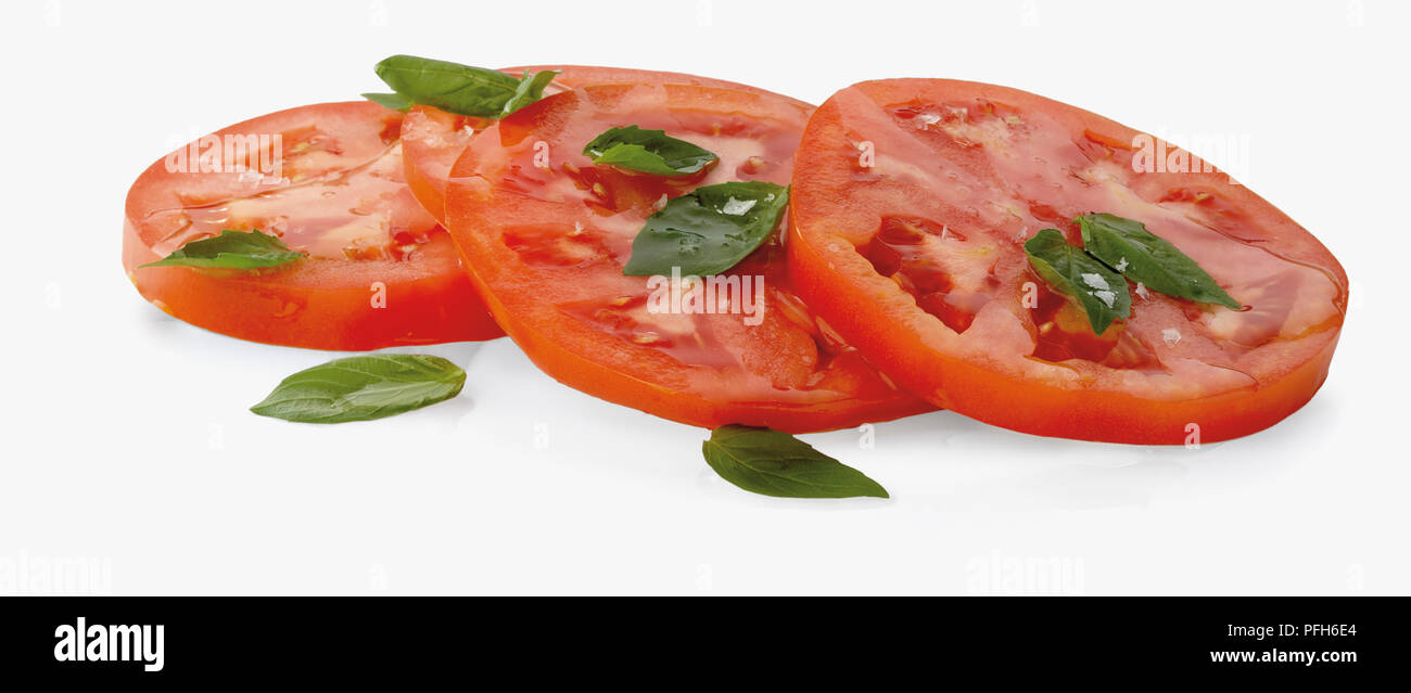 Three tomato slices, basil leaves and salt Stock Photo - Alamy