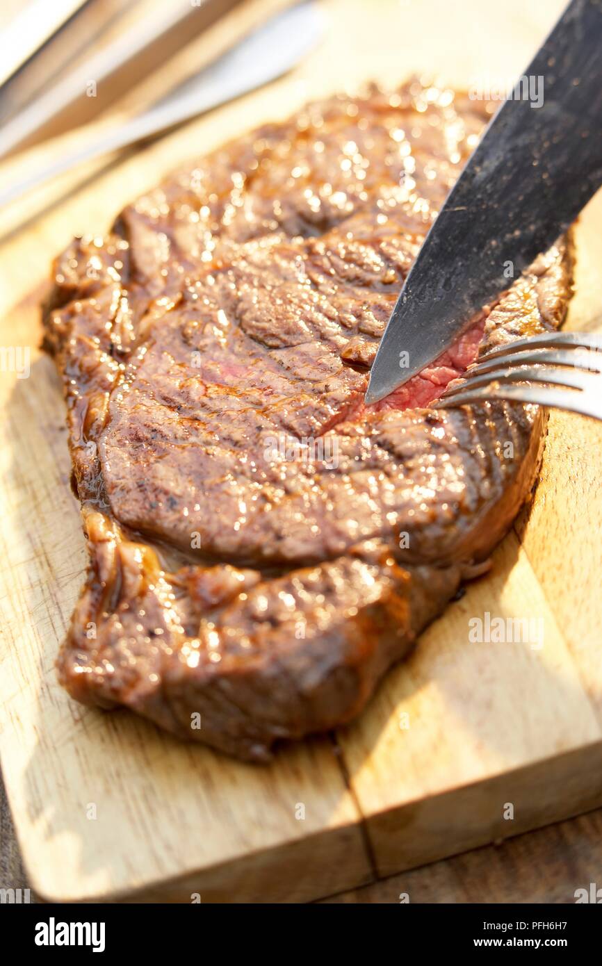 Testing doneness of piece of steak using 'nick and peek' method Stock ...