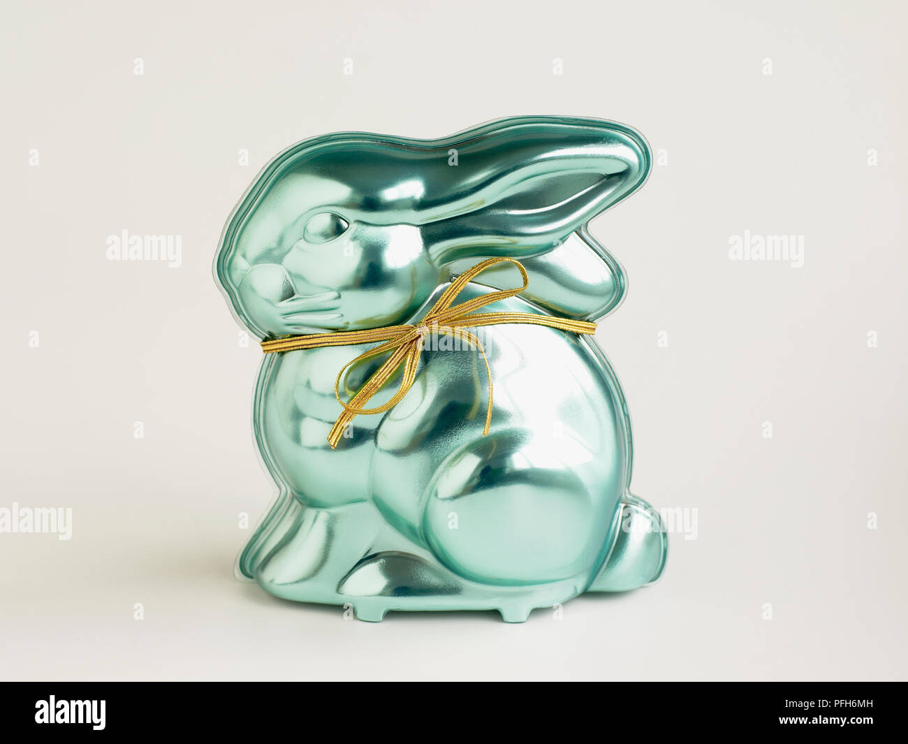 Silver-green rabbit with gold bow around neck Stock Photo - Alamy