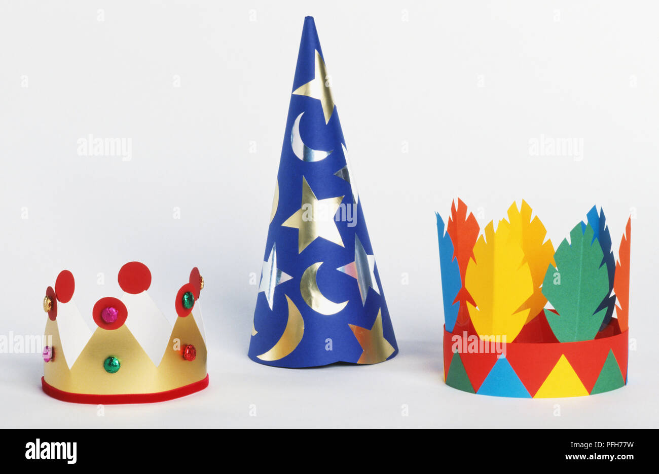 Paper gold crown, wizard hat and feather crown Stock Photo - Alamy