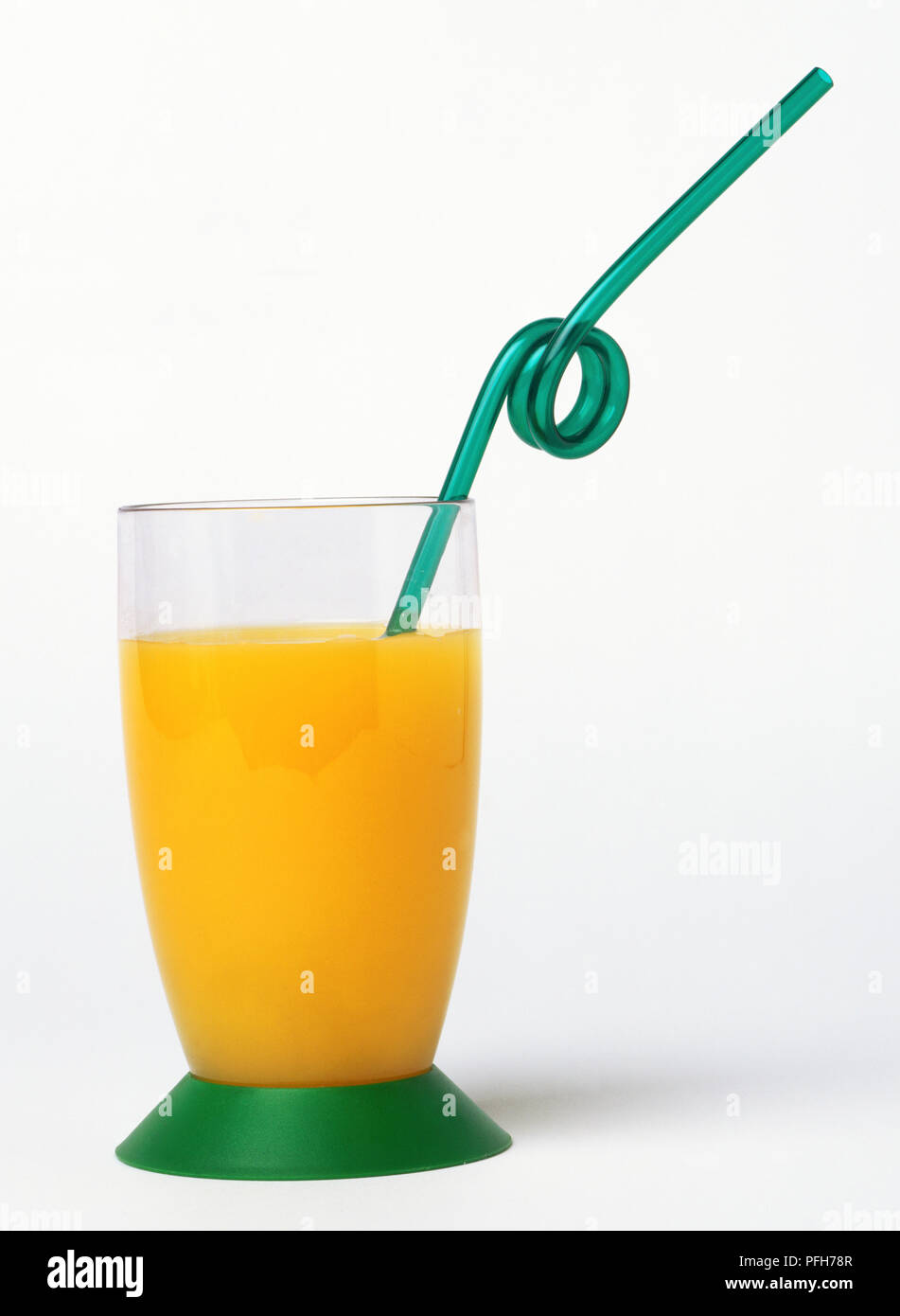 Green drinking straw twisted into loop in a glass of orange juice Stock ...