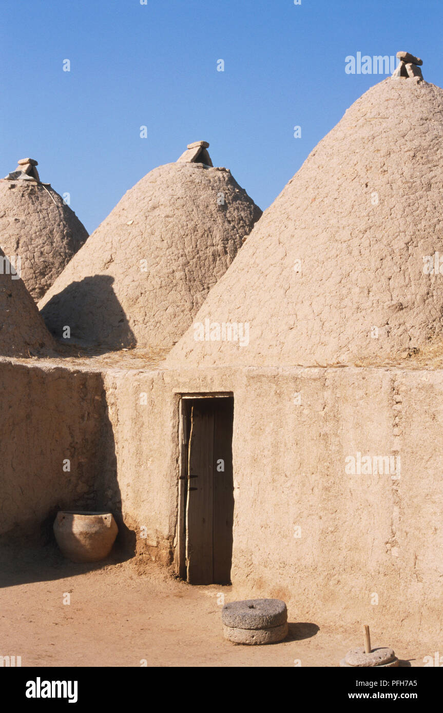 Open doorway to a cluster of houses with conical roofs, blue sky ...