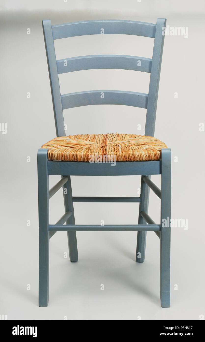 A blue-grey wooden chair with a wicker seat Stock Photo - Alamy