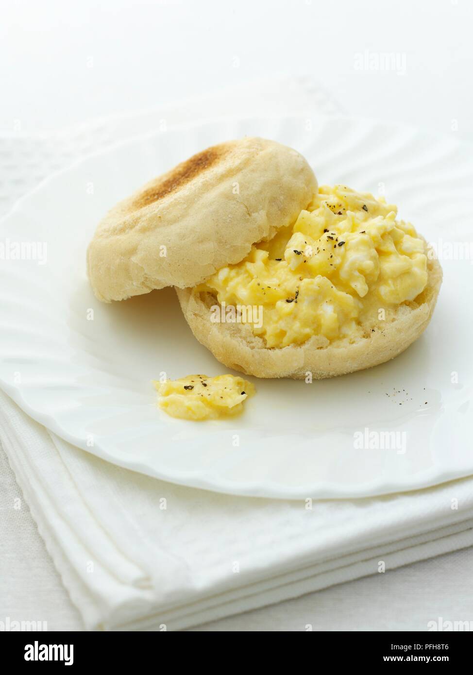 English muffin topped with fried eggs and seasoned with black pepper ...