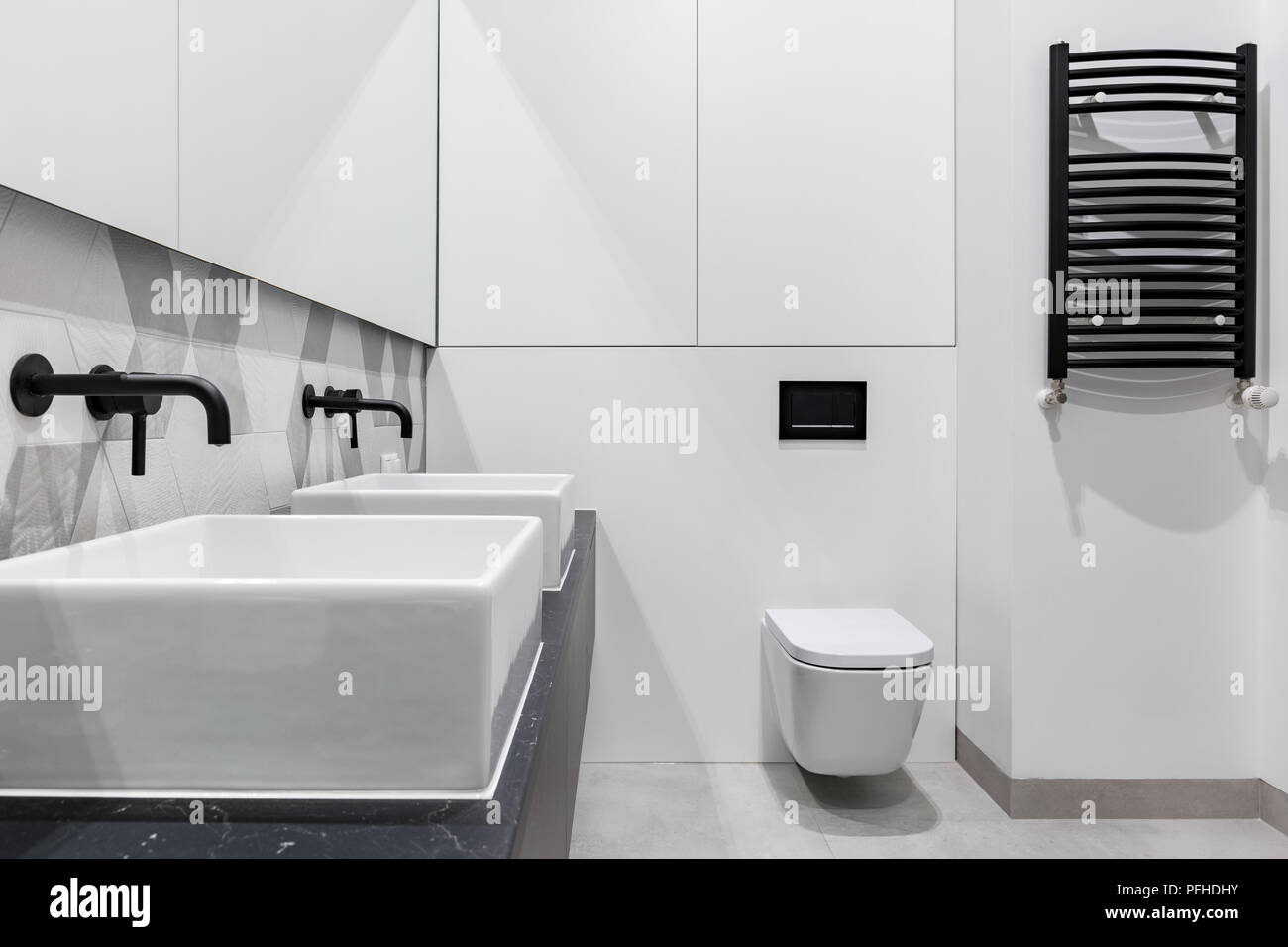 White bathroom with two basins, cubic toilet and black details Stock ...