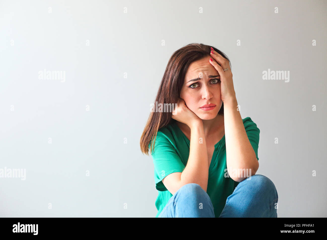 Portrait of a sad woman looking thoughtful about her troubles in front ...