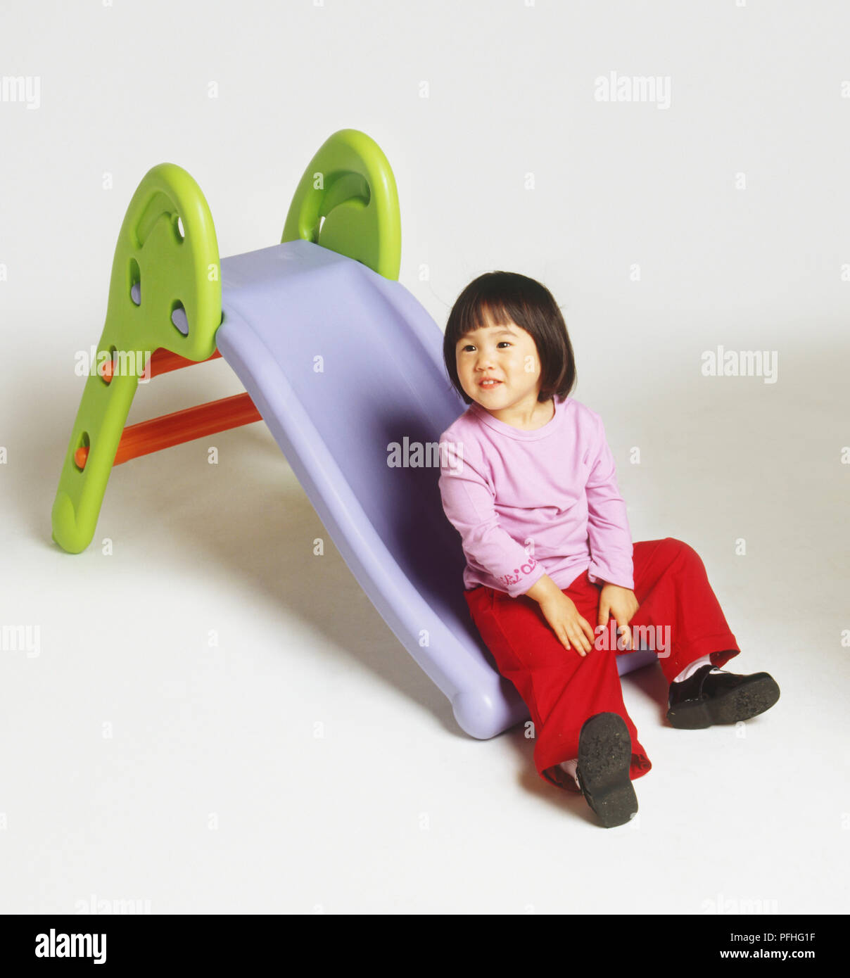 Girl at bottom of slide, looking sideways Stock Photo - Alamy