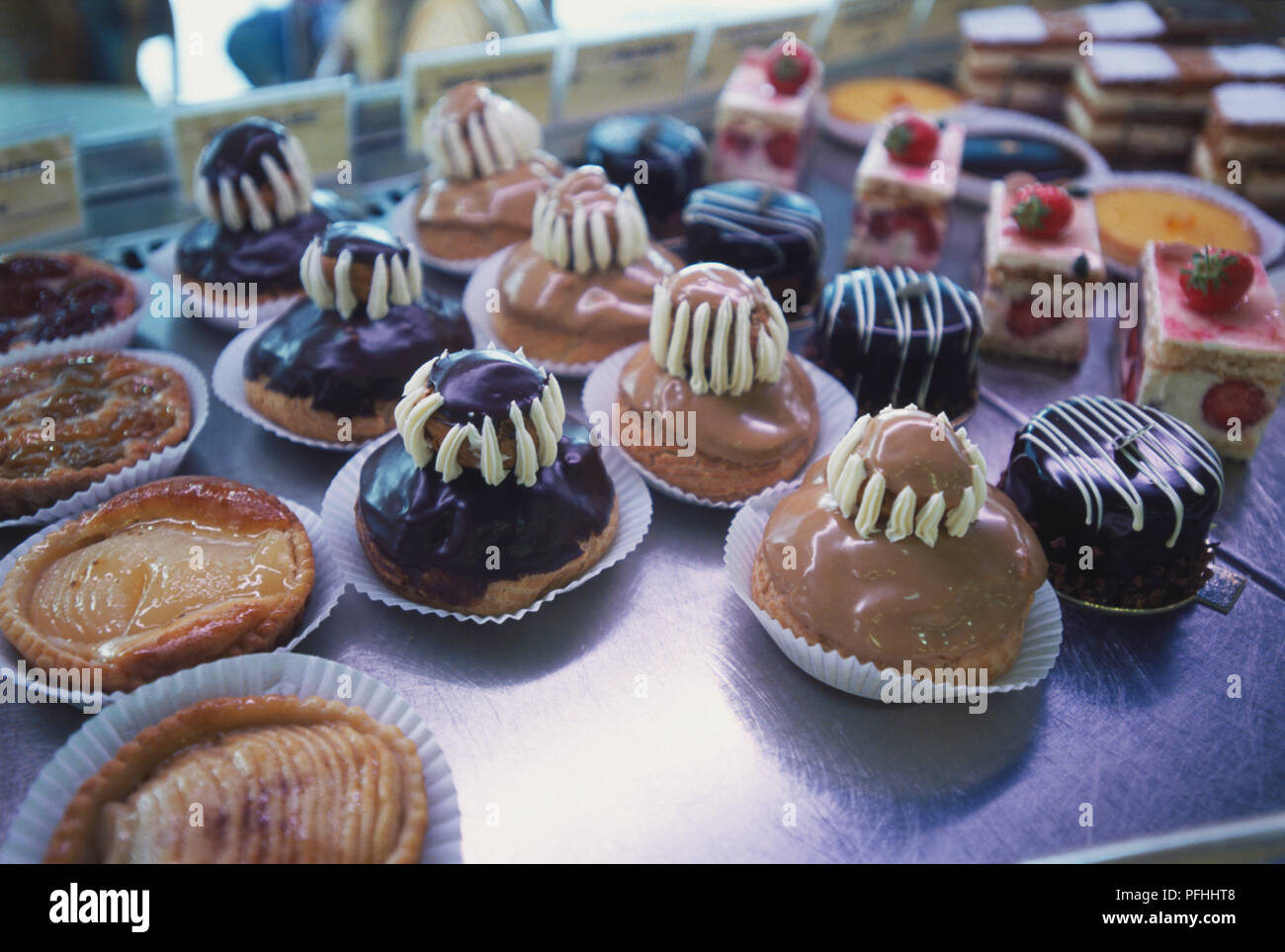 Rows of assorted decorated cup cakes in shop display, close up Stock ...