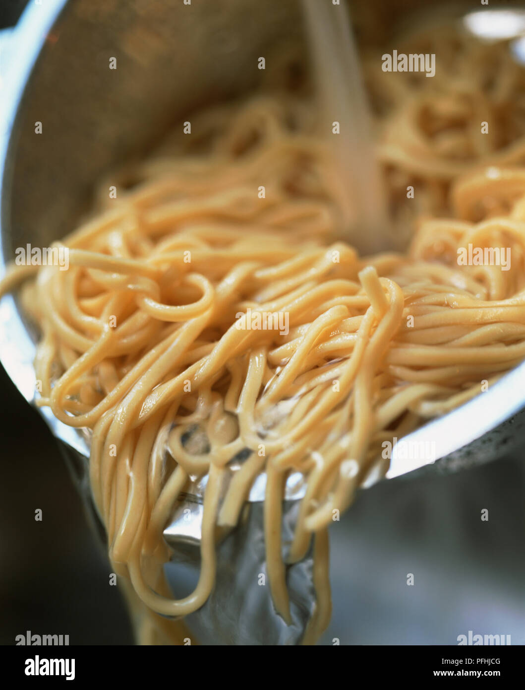 Noodles being drained in a colander Stock Photo - Alamy