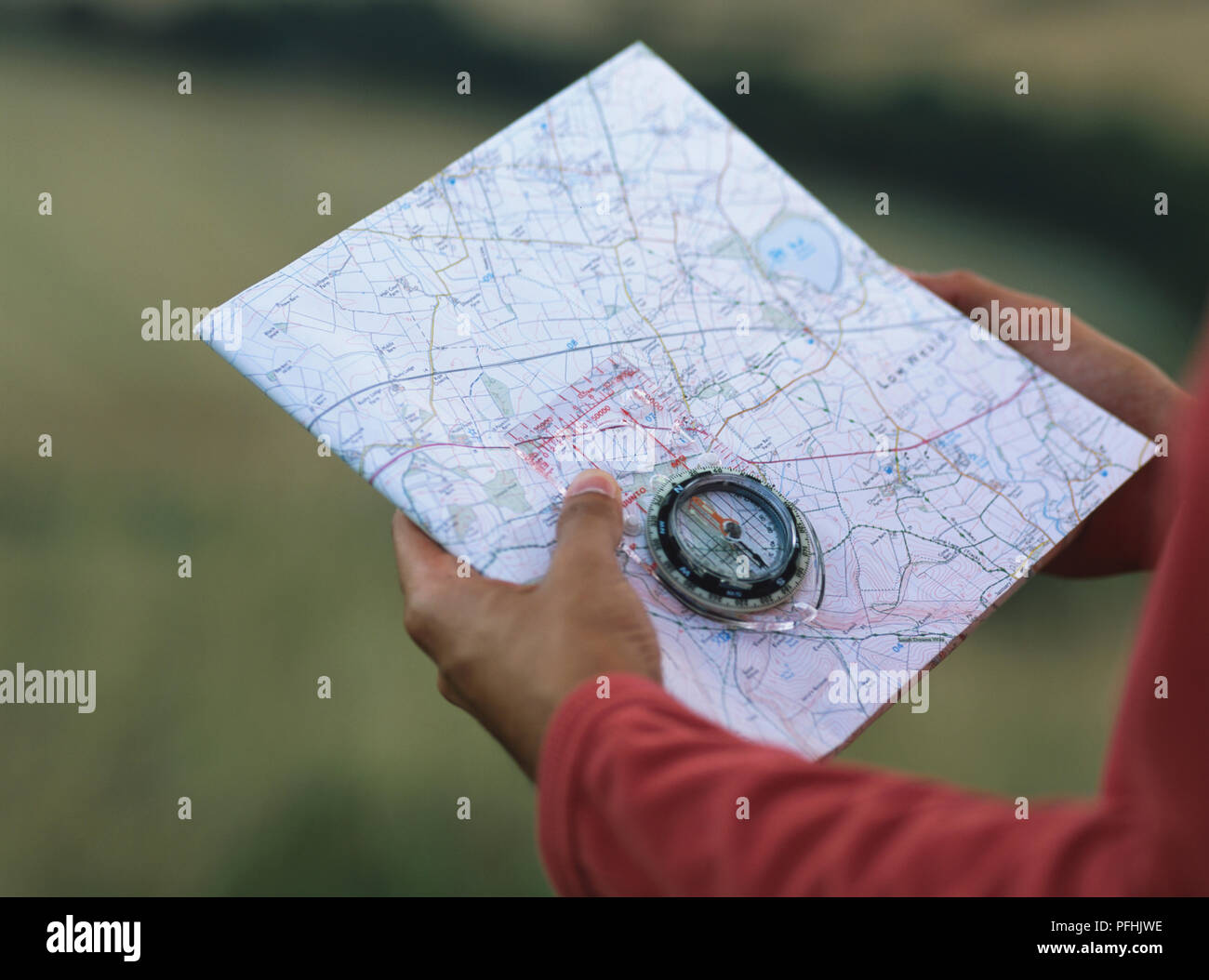 Man holding a map and compass, close up Stock Photo - Alamy