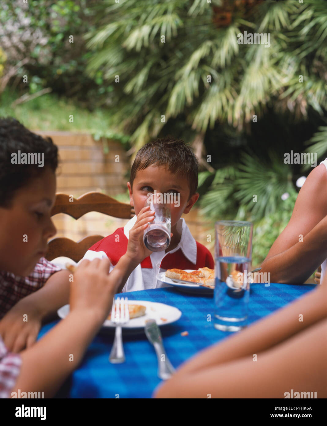 Children eating and drinking around a table Stock Photo - Alamy