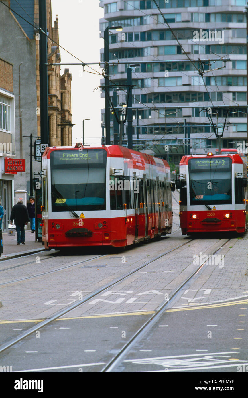 Two red trams travelling side by side in the street, front view Stock ...
