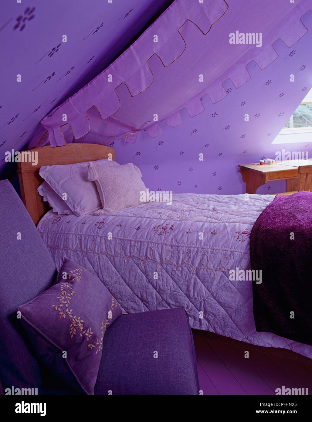 Bed and a chair under a sloping roof Stock Photo - Alamy