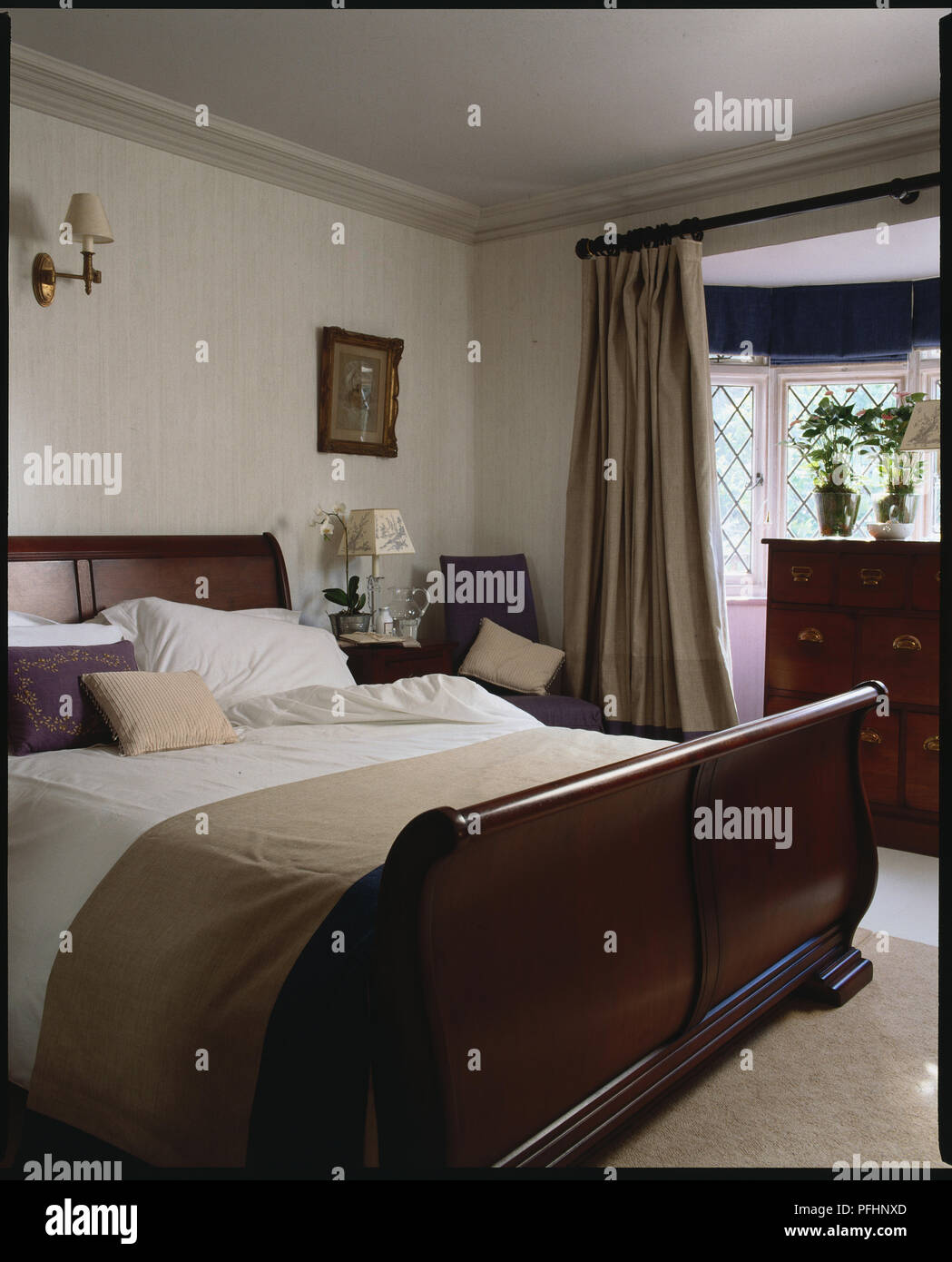 A large double bed in a room with a bay window Stock Photo - Alamy