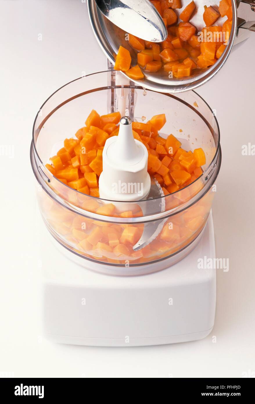 Pouring chopped carrots into liquidiser Stock Photo - Alamy