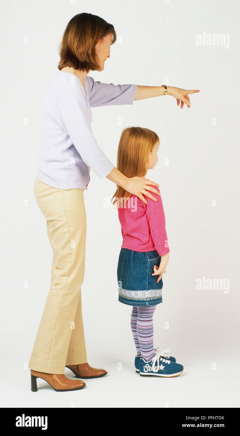 Woman and girl looking in direction woman is pointing to, her other ...