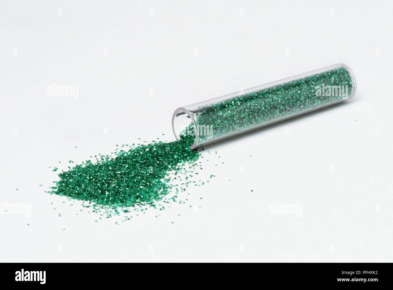 Green glitter spilling from a horizontal plastic tube, side view Stock ...