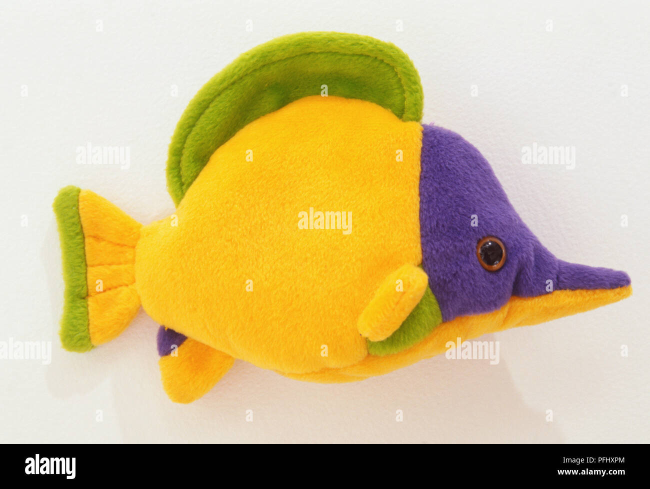 Yellow, purple and green stuffed toy fish, side view Stock Photo - Alamy