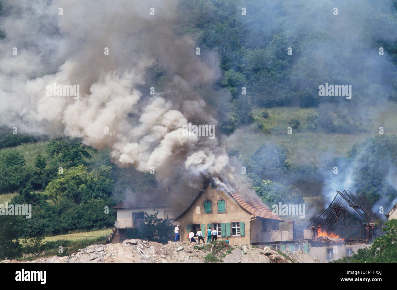 France, fire burning down hillside house and barn, thick smoke rising ...