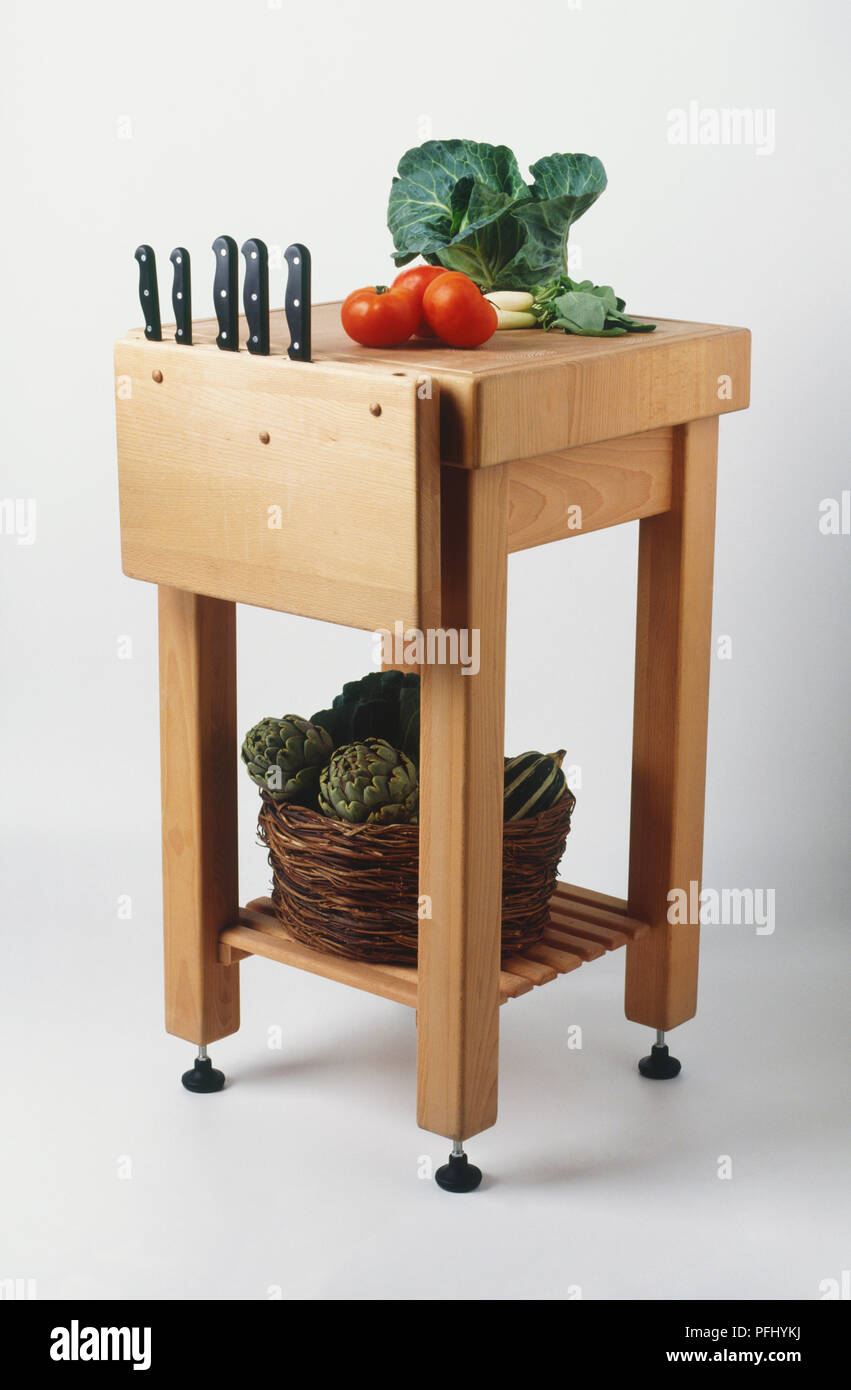 Butcher's block, shelf at bottom holding basket of artichokes, cabbage ...