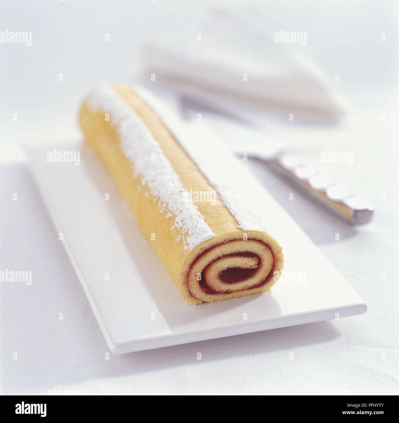 Sponge roulade dusted with icing sugar, high angle view Stock Photo - Alamy