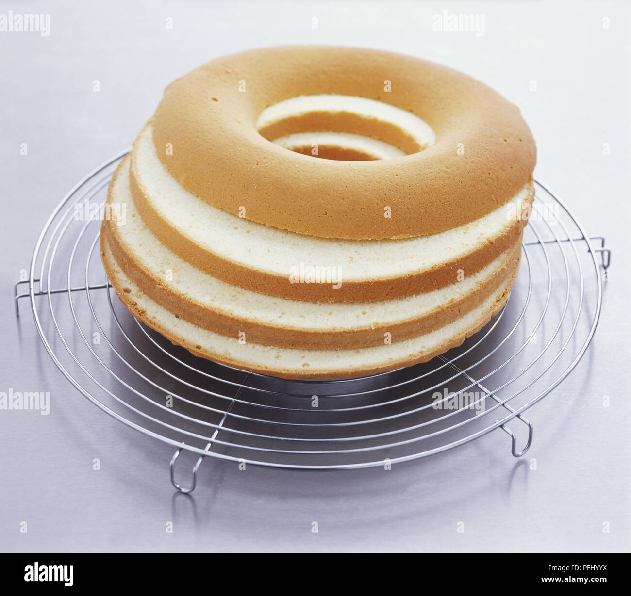 Sponge cake cut into four layers resting on a wire rack Stock Photo - Alamy