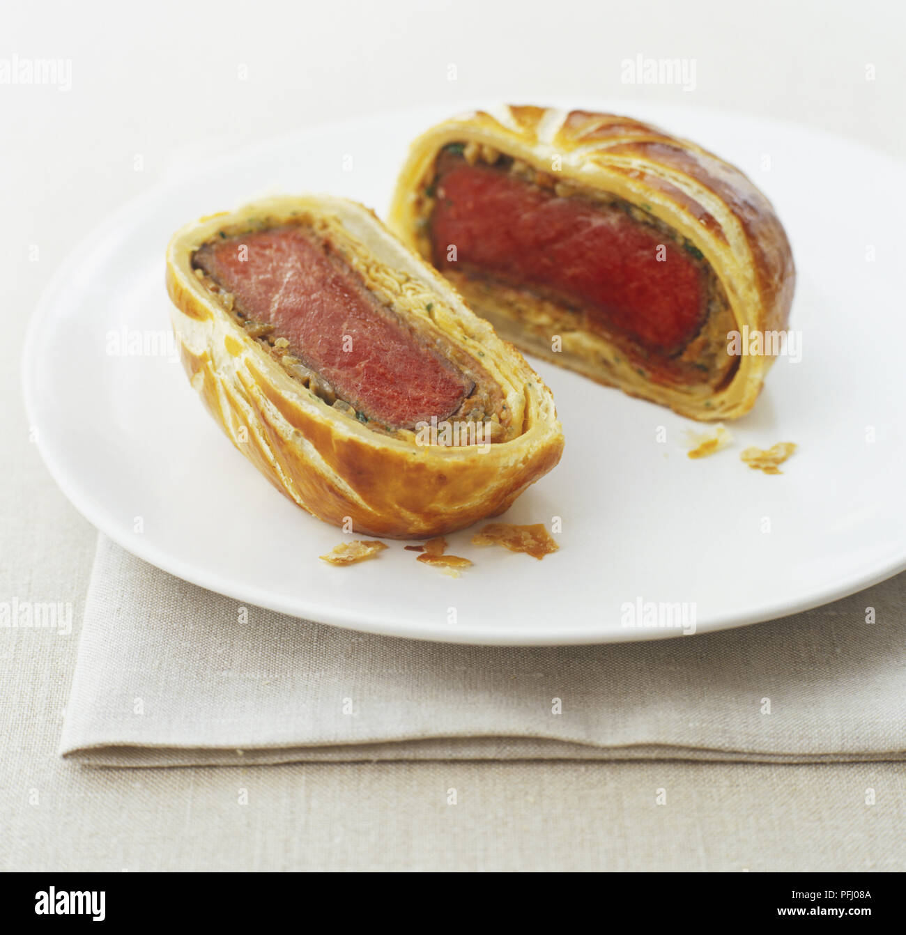 Beef Wellington, cut in two halves, showing rare-cooked fillets inside ...