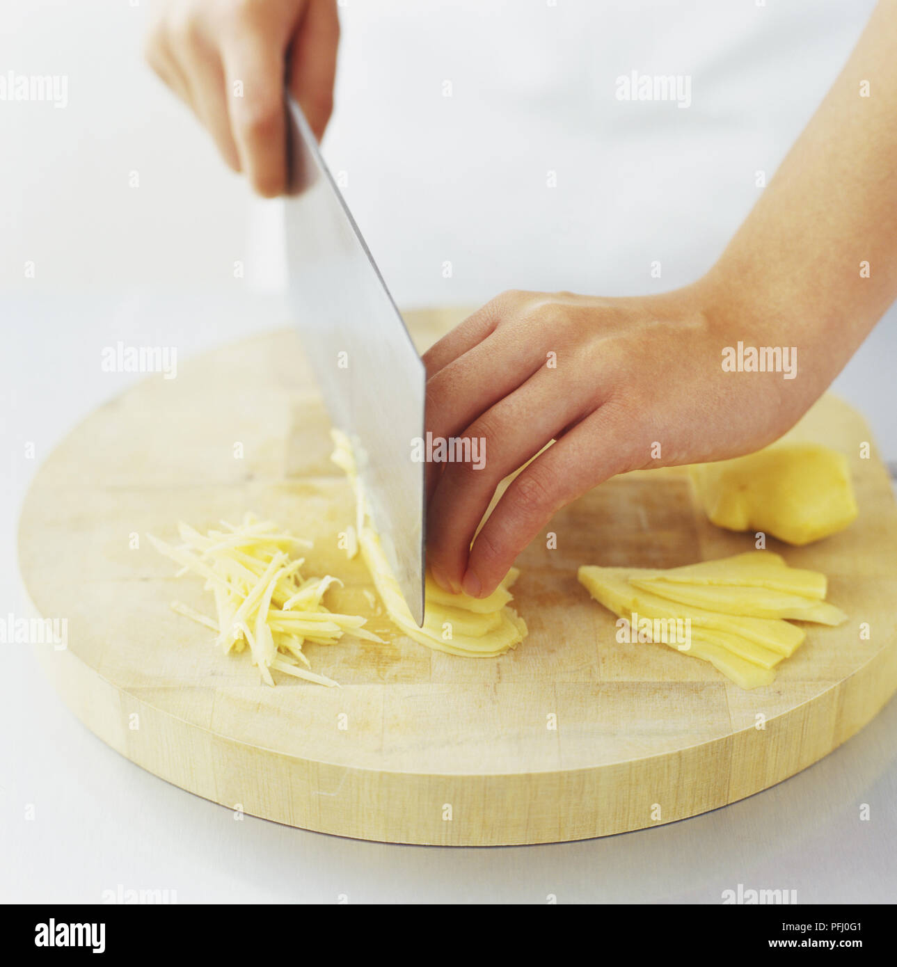 Finely shredding ginger, using a cleaver Stock Photo - Alamy
