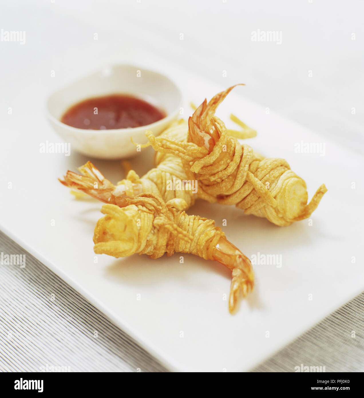 Noodle-wrapped tiger prawns served with sweet chili dip Stock Photo - Alamy
