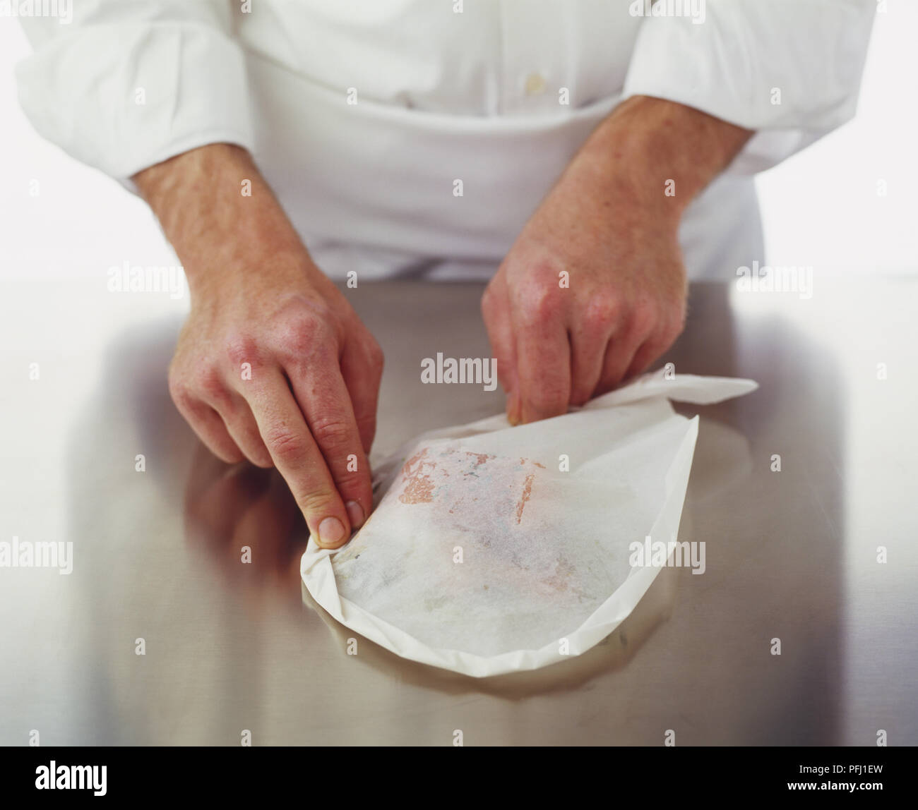 Wrapping fish in a paper parcel (en papillote Stock Photo - Alamy
