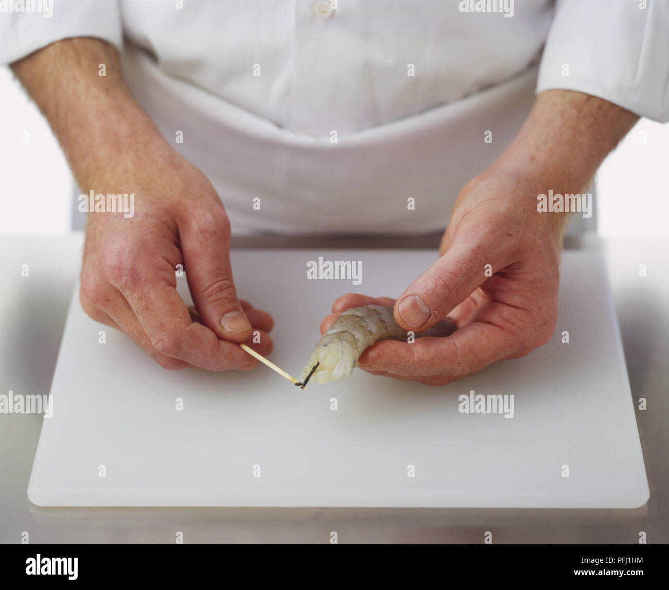Using a cocktail stick to remove the vein from a prawn Stock Photo - Alamy