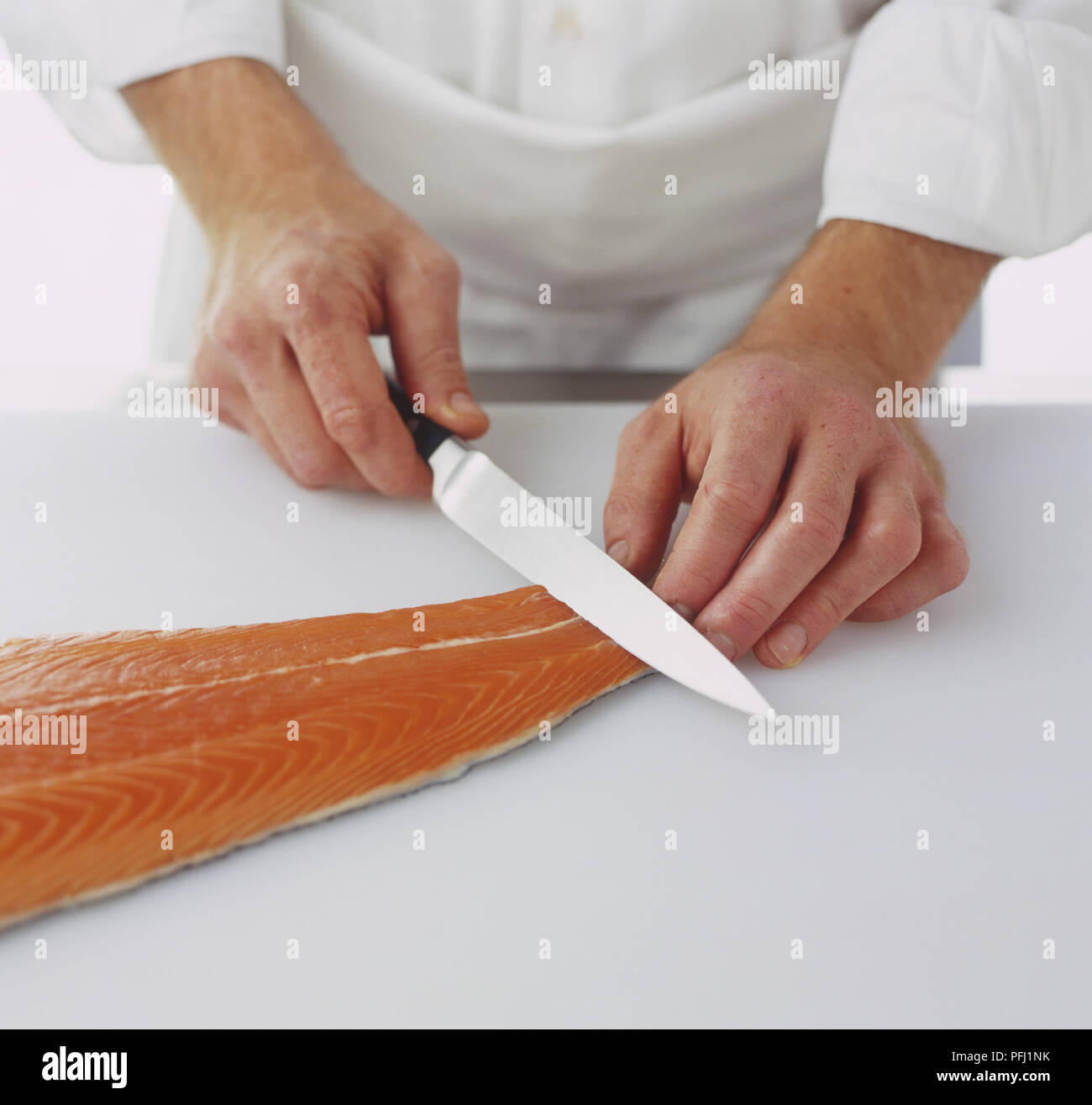Cutting into tail end of a salmon fillet Stock Photo - Alamy