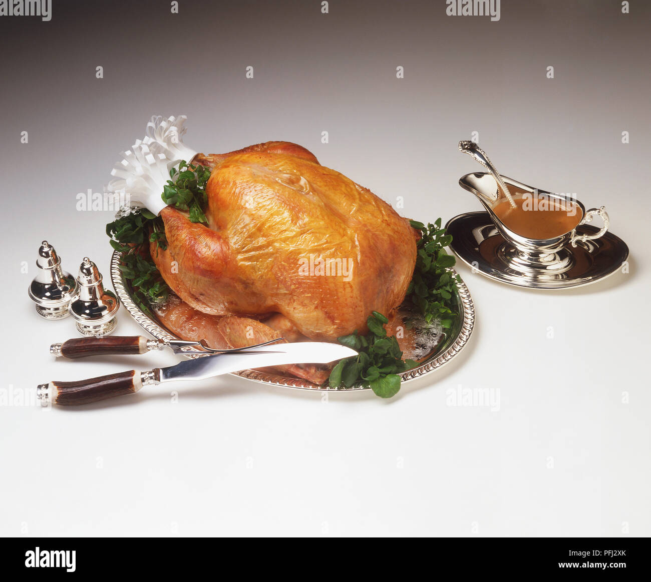 Roast turkey on silver serving platter garnished with herbs, silver ...