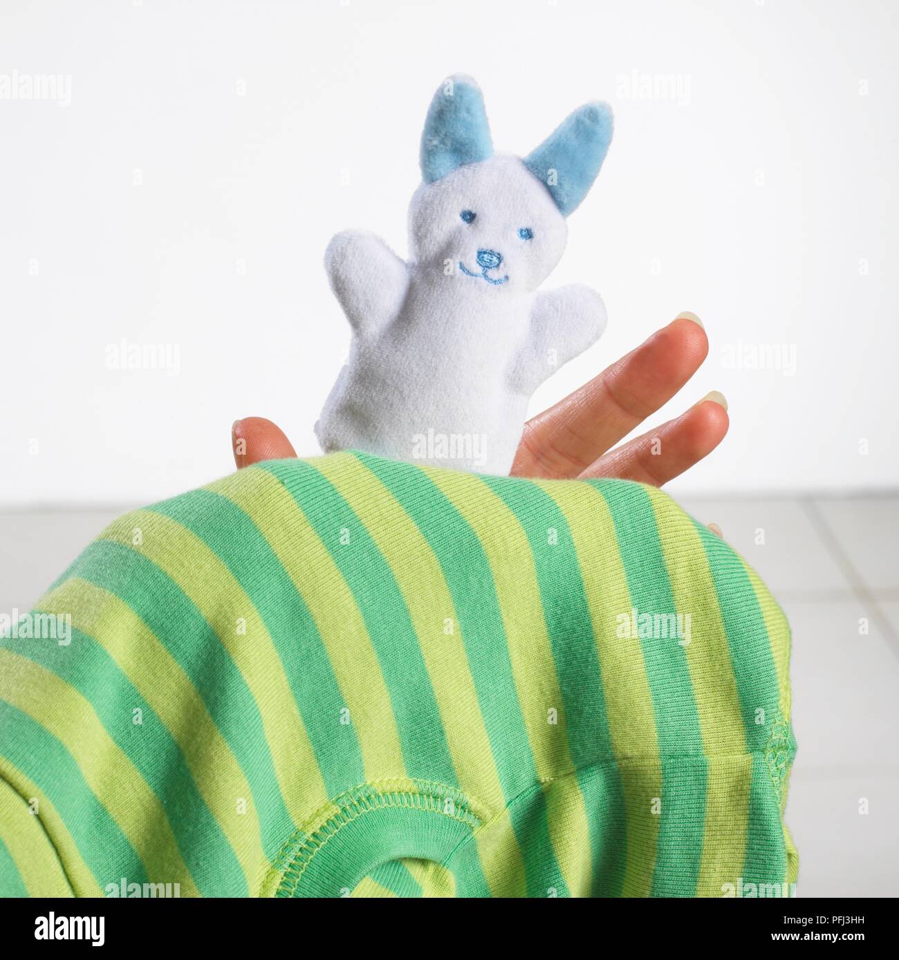 Puppet on finger behind striped top on back of chair Stock Photo - Alamy