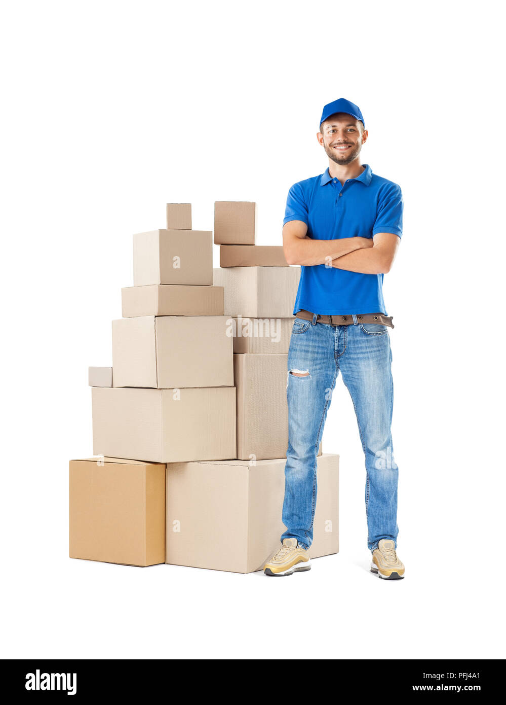 Full length portrait of delivery man standing near stack of boxes ...
