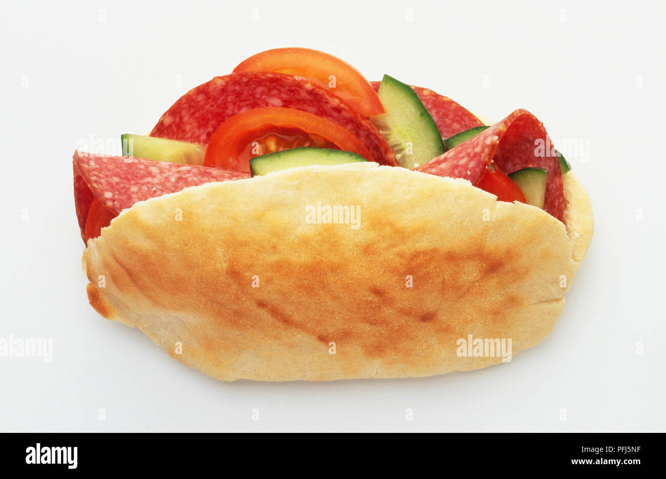Pitta bread filled with sausage slices and vegetables, side view Stock ...