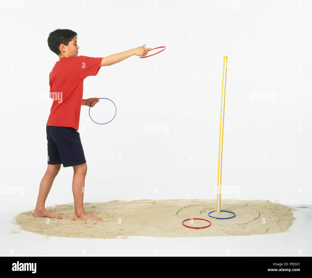 Boy throwing hoops, on sand Stock Photo - Alamy